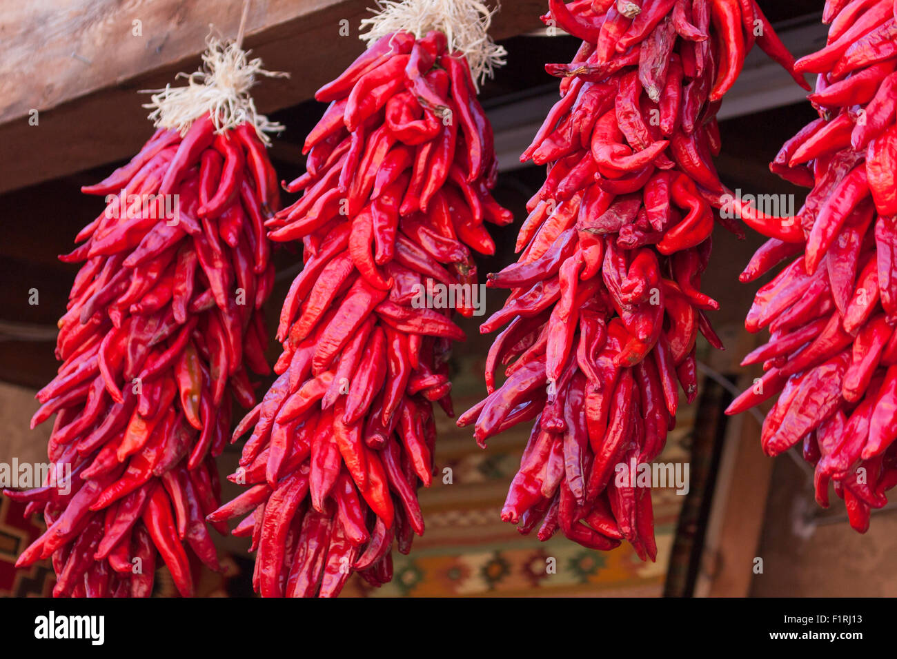 Groups of red chili peppers hanging in a southwestern open air market ...