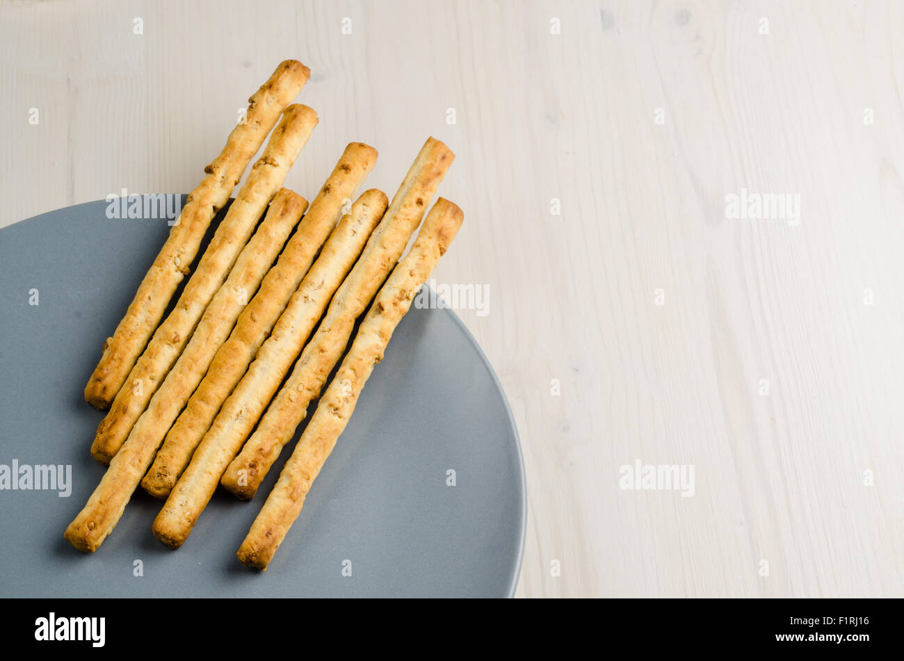 rustic breadsticks in a dish on wood table, close up, background Stock ...