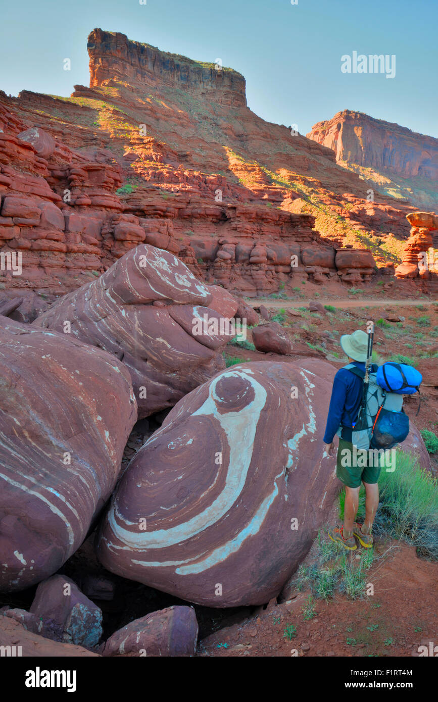 Hiker takes a break in the shade at Hurrah Pass in Canyonlands National ...
