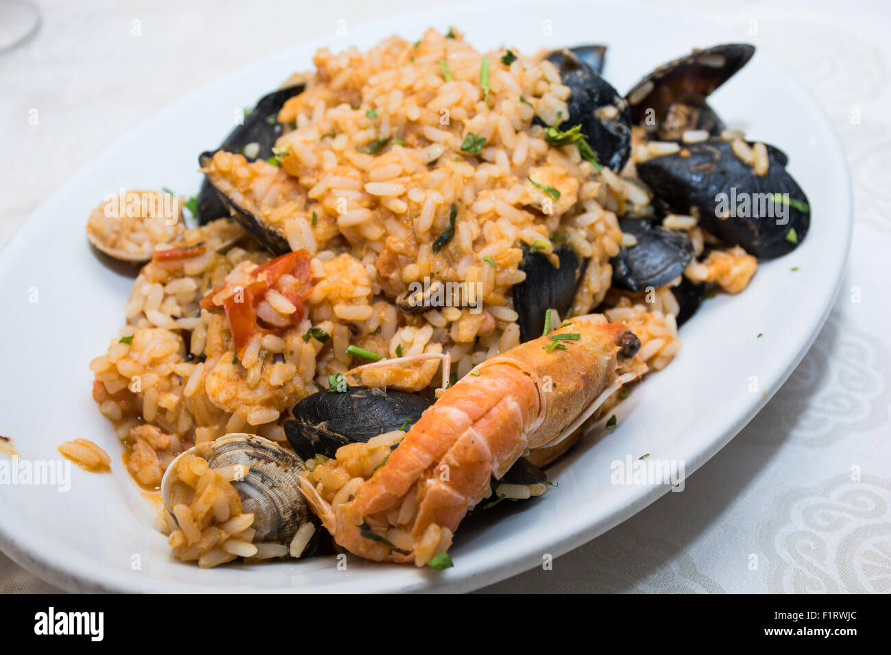 A dish of seafood rice pics, with mussels, clams, shrimp, mussels ...
