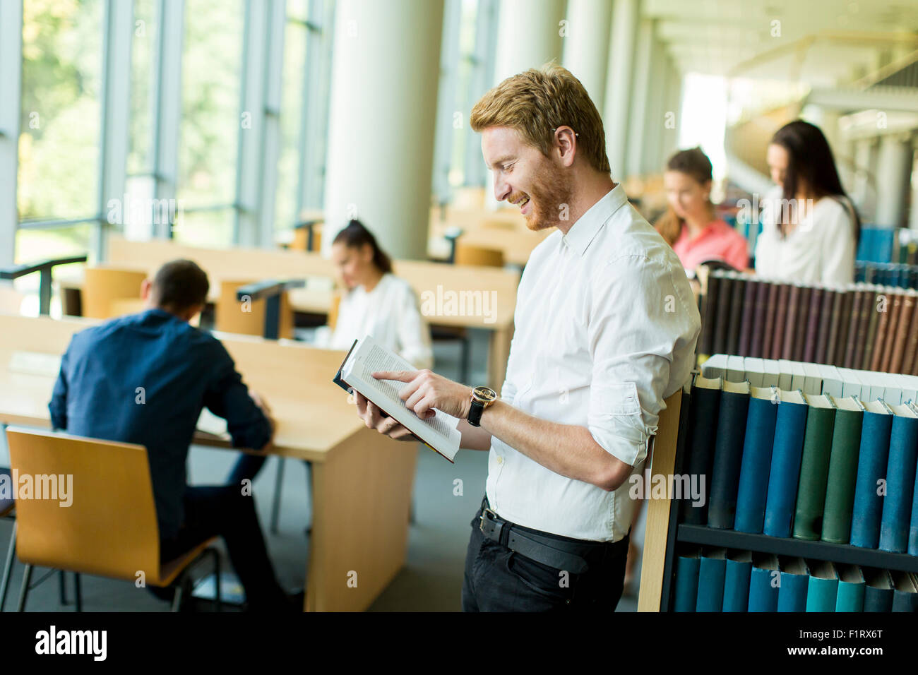 Young man in the library Stock Photo - Alamy