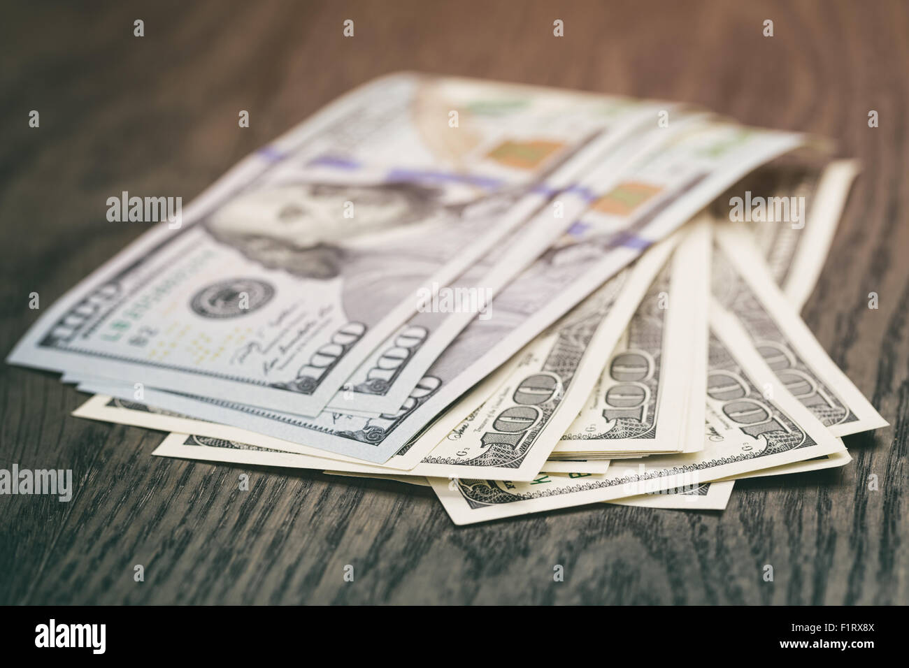 hundred dollar bills on wood table Stock Photo - Alamy