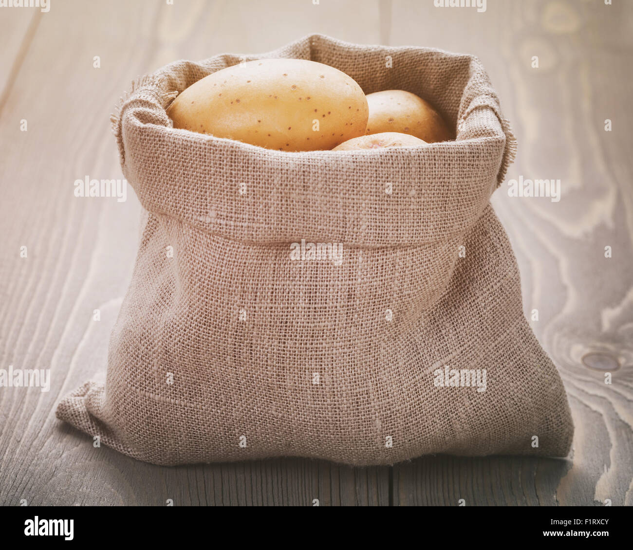 organic raw potato in sack bag on wood table Stock Photo - Alamy