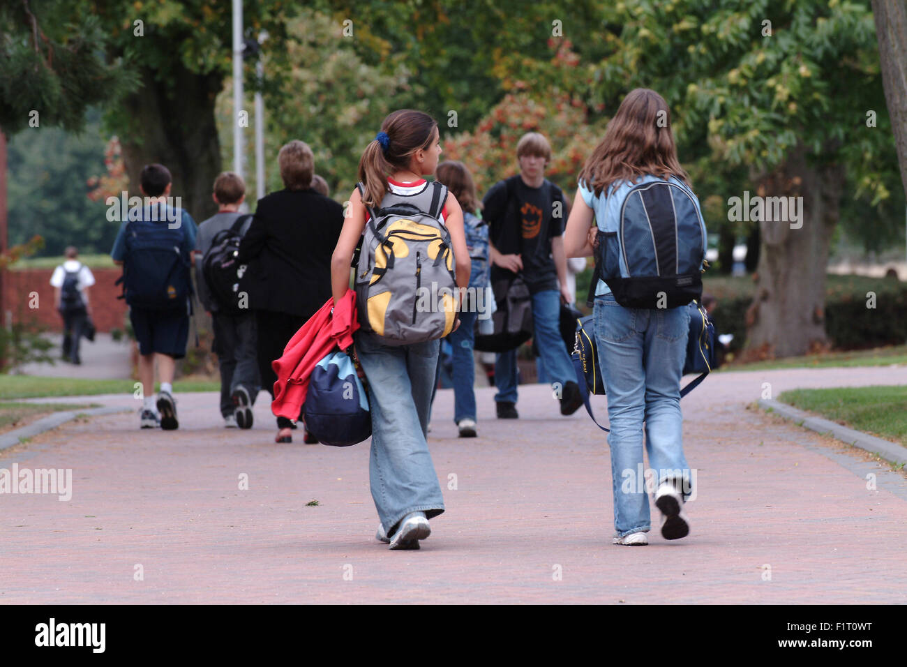 Children leaving school with backpacks, walking away from camera Stock ...