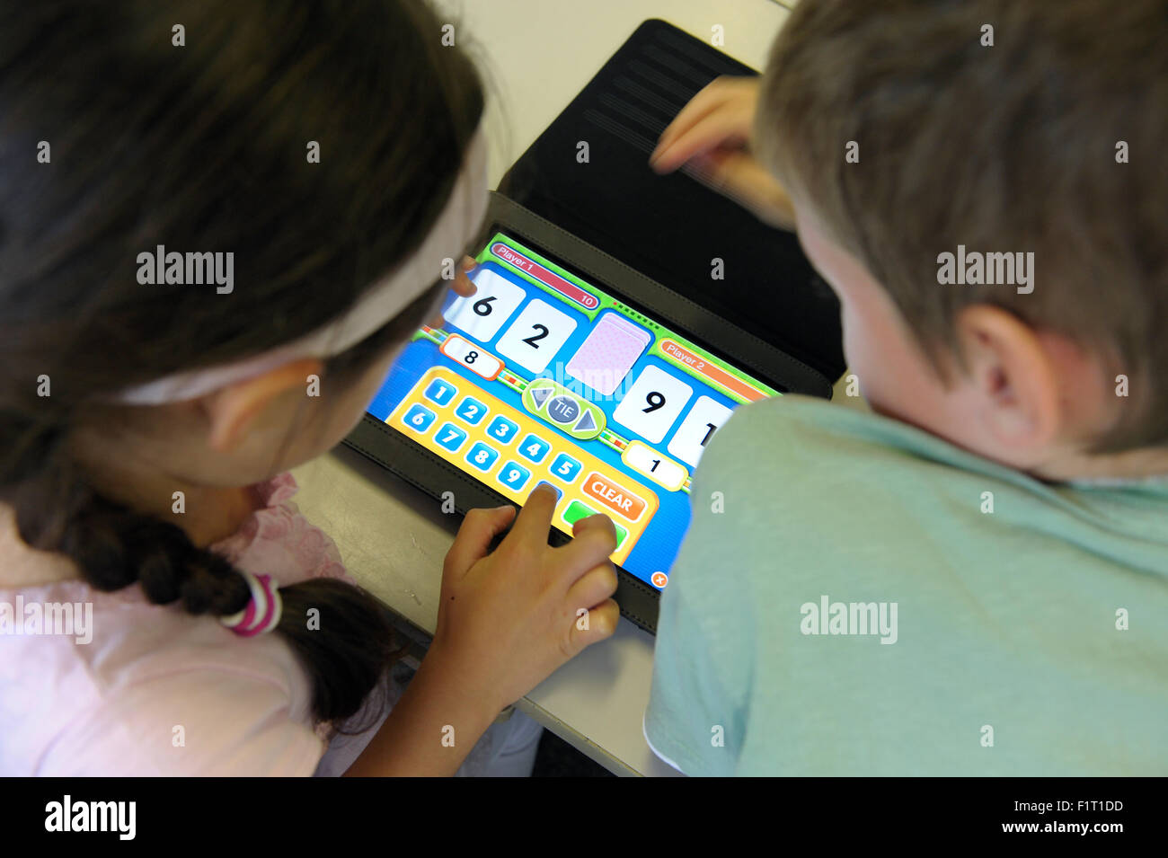 Primary school children using an iPad in the classroom Stock Photo - Alamy