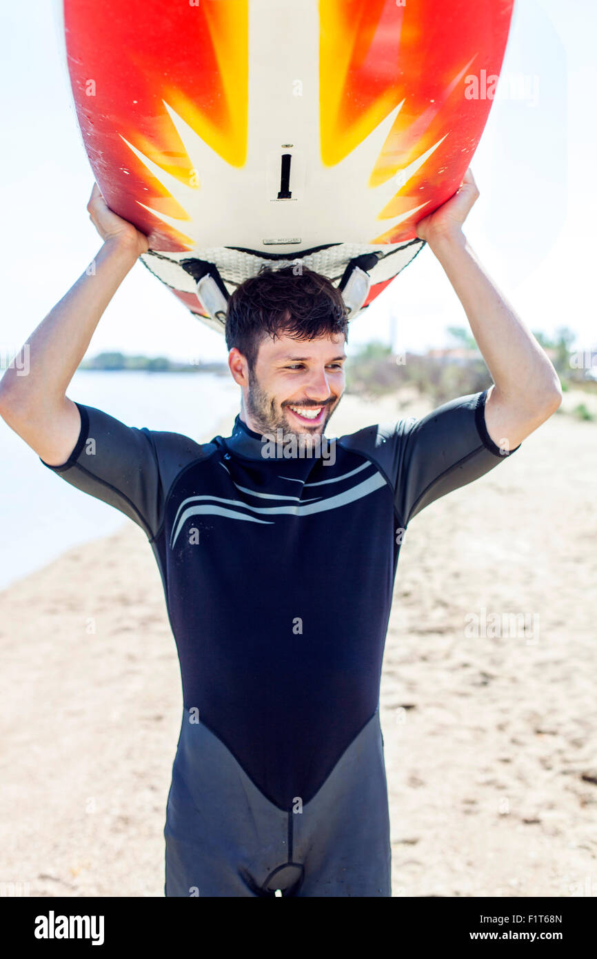 Surfer carrying surfboard on head Stock Photo - Alamy