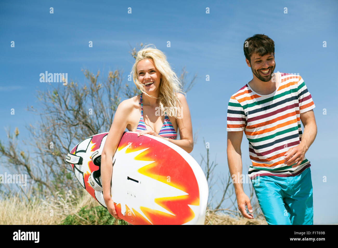 Two people with surfboard on beach Stock Photo - Alamy