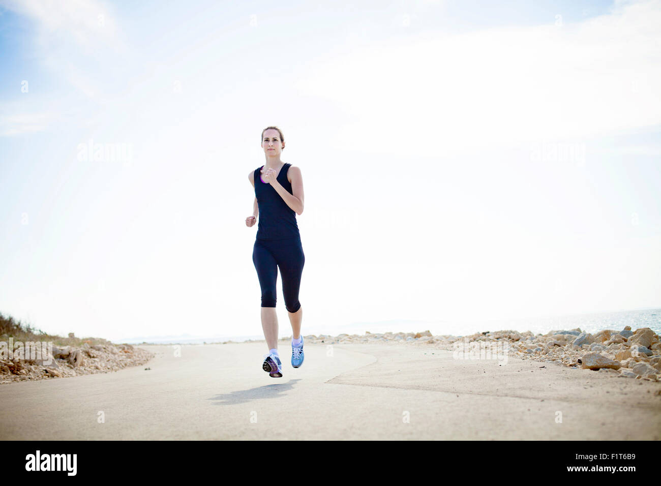Young woman running on waterfront path Stock Photo - Alamy