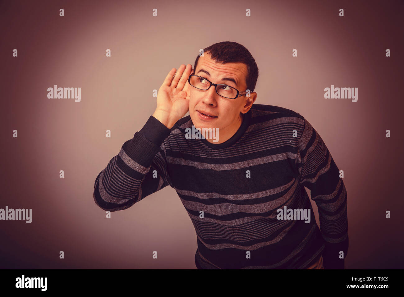 male of European appearance brunet put his hand to his ear, eave Stock ...