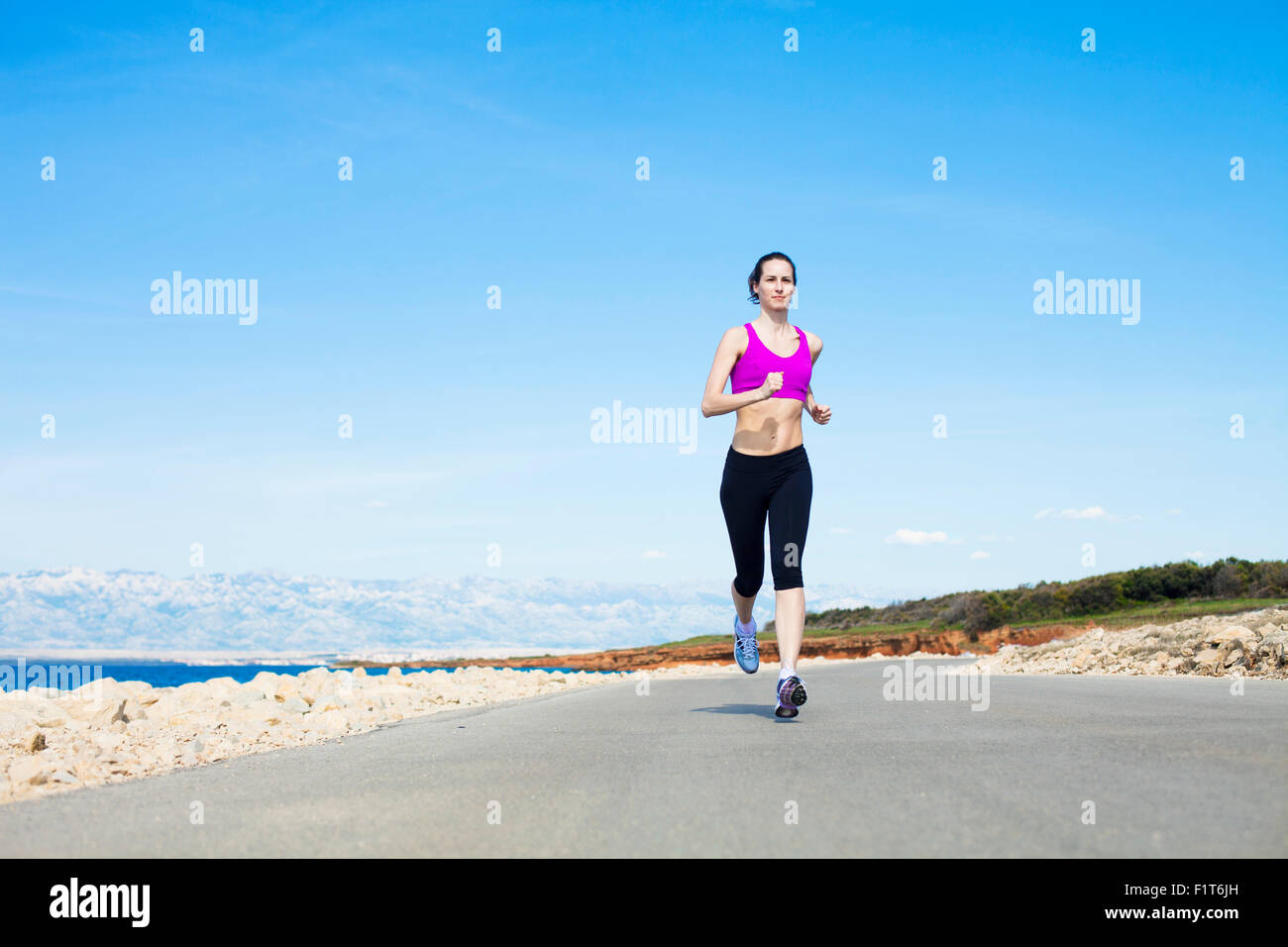 Young woman running on waterfront path Stock Photo - Alamy