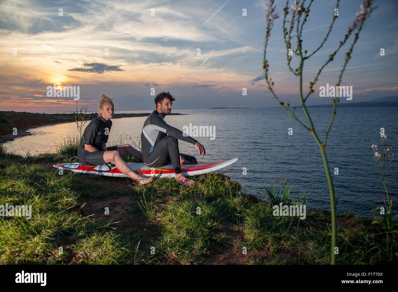 Surfers sitting on surfboard Stock Photo - Alamy