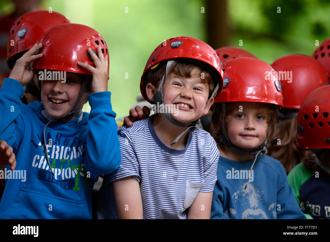 Children try their helmets before exercising on an assault course at an ...