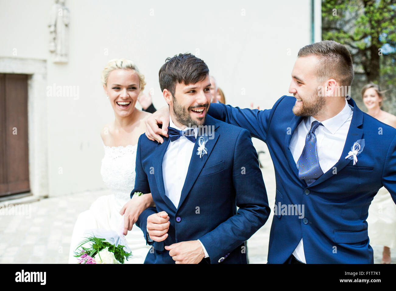 Bridegroom and wedding guest embracing Stock Photo - Alamy