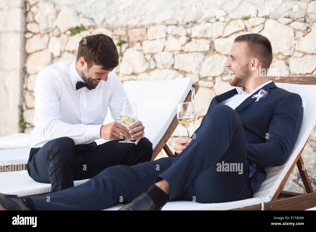 Groom and friend drinking champagne on wedding party Stock Photo - Alamy