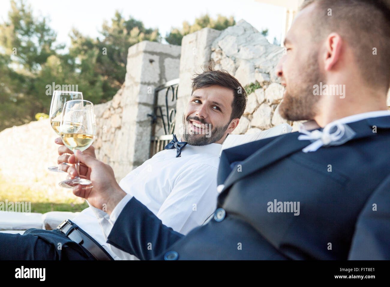 Groom and friend drinking champagne on wedding party Stock Photo - Alamy