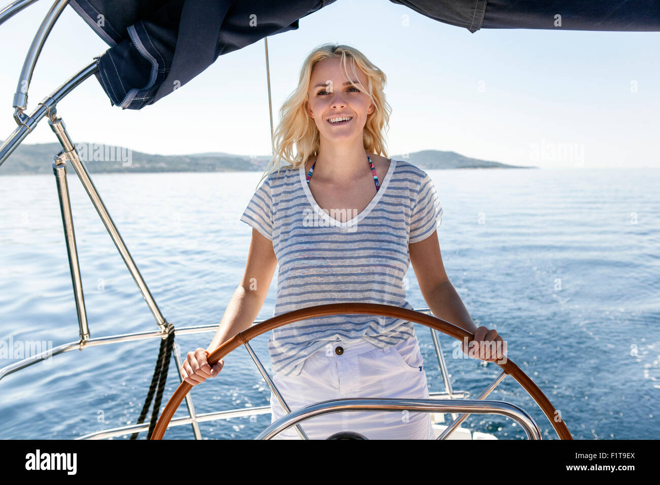 Young woman at helm sailboat hi-res stock photography and images - Alamy