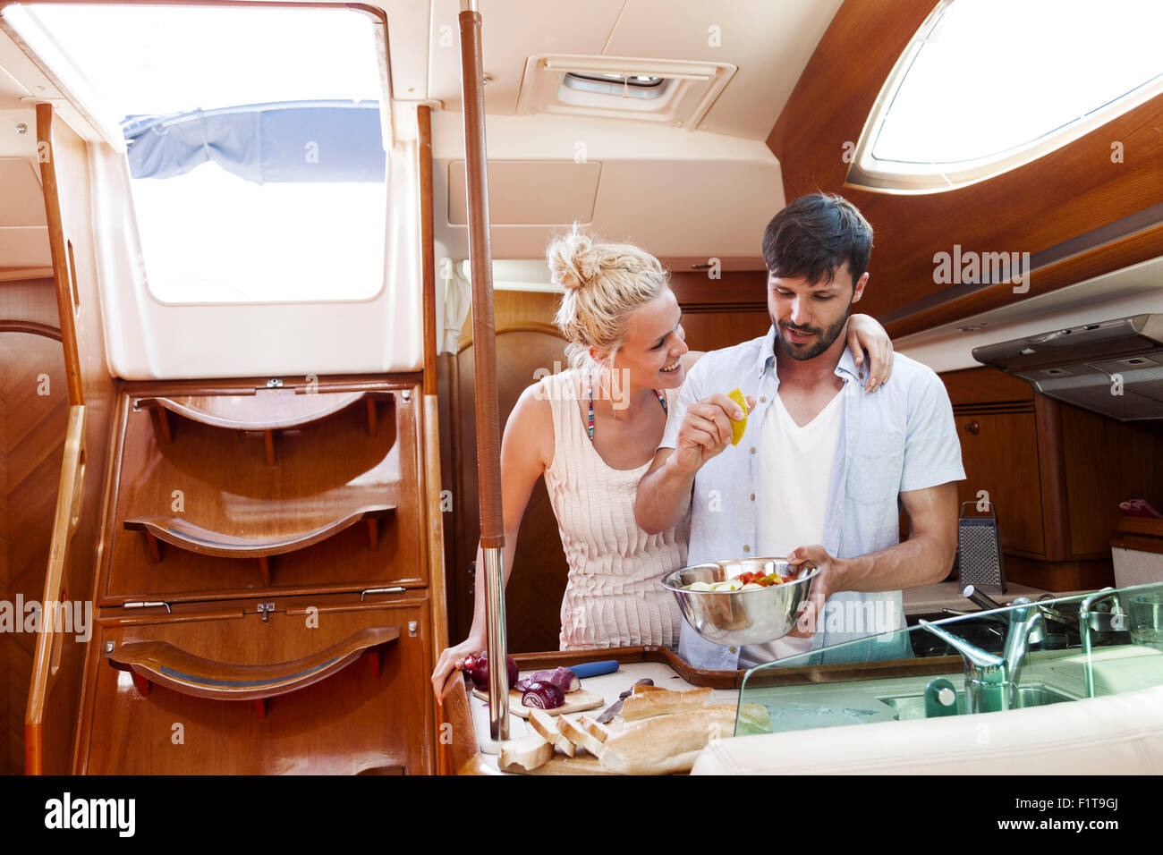 Young couple cooking together in galley of yacht, Adriatic Sea Stock ...