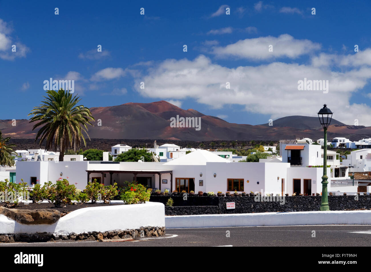 The village of Yaiza with the volcanoes of Timanfaya National Park in ...
