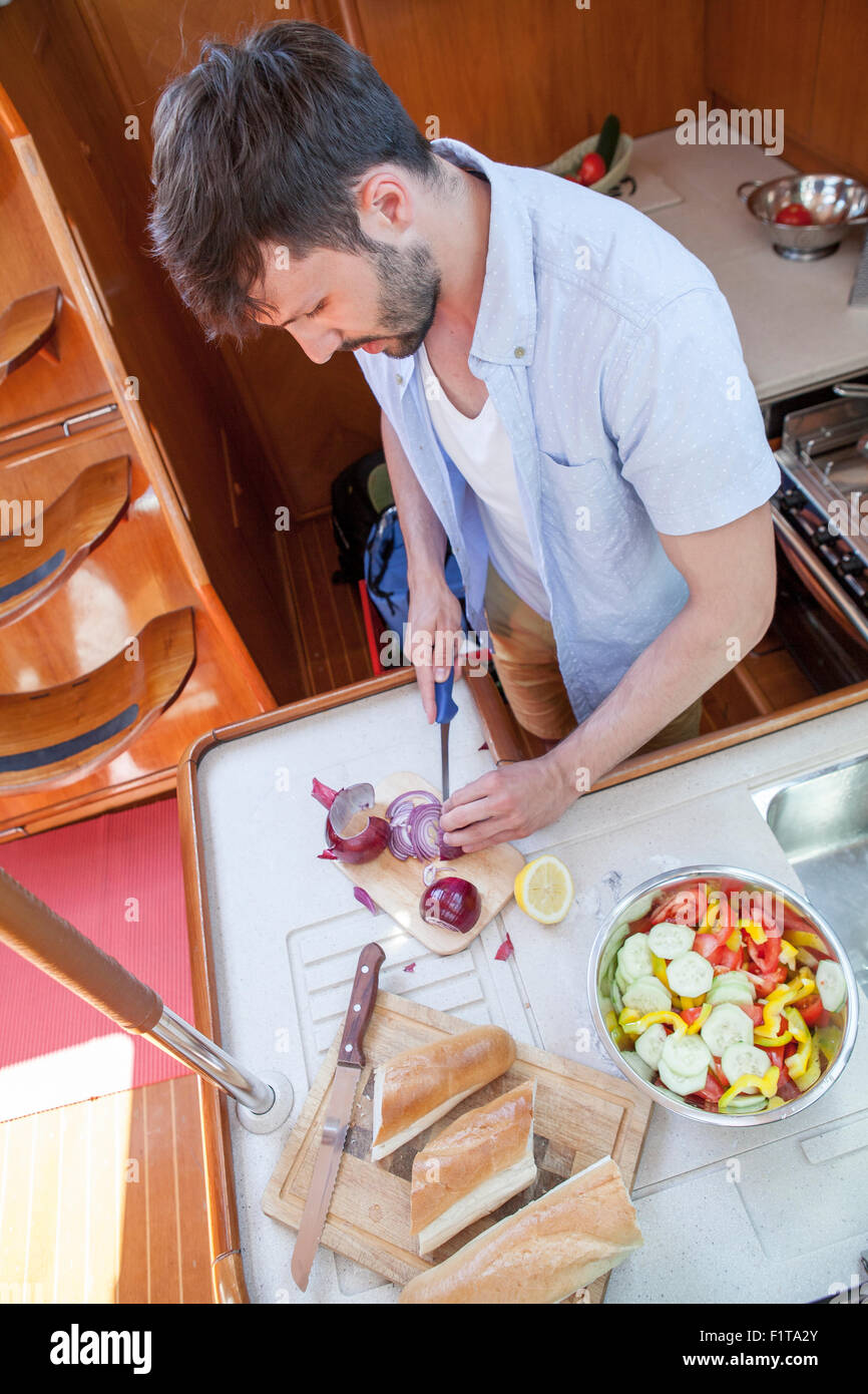 Young man cooking in galley of yacht, Adriatic Sea Stock Photo - Alamy
