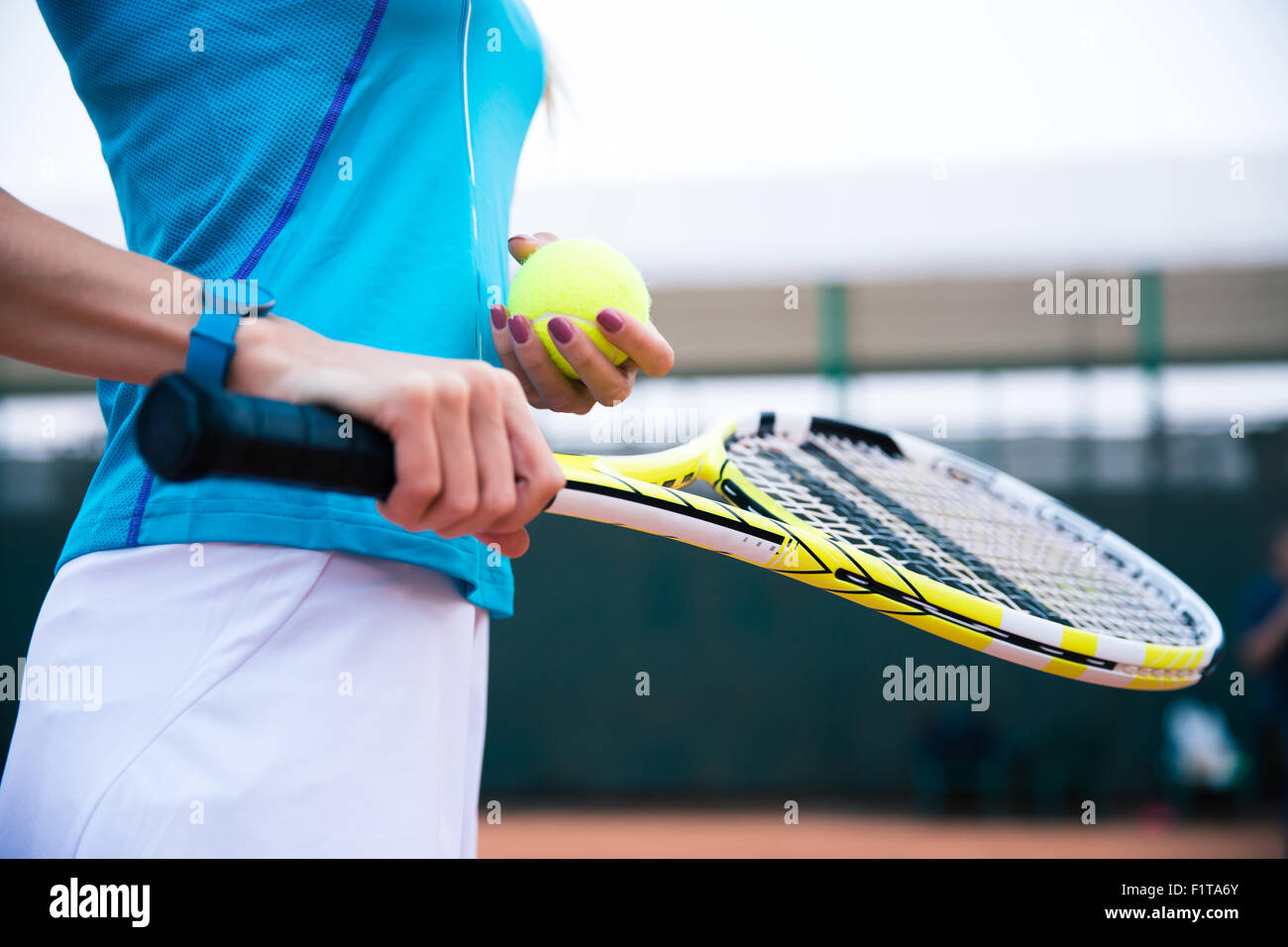Closeup portrait of a female tennis player holding racket and ball ...