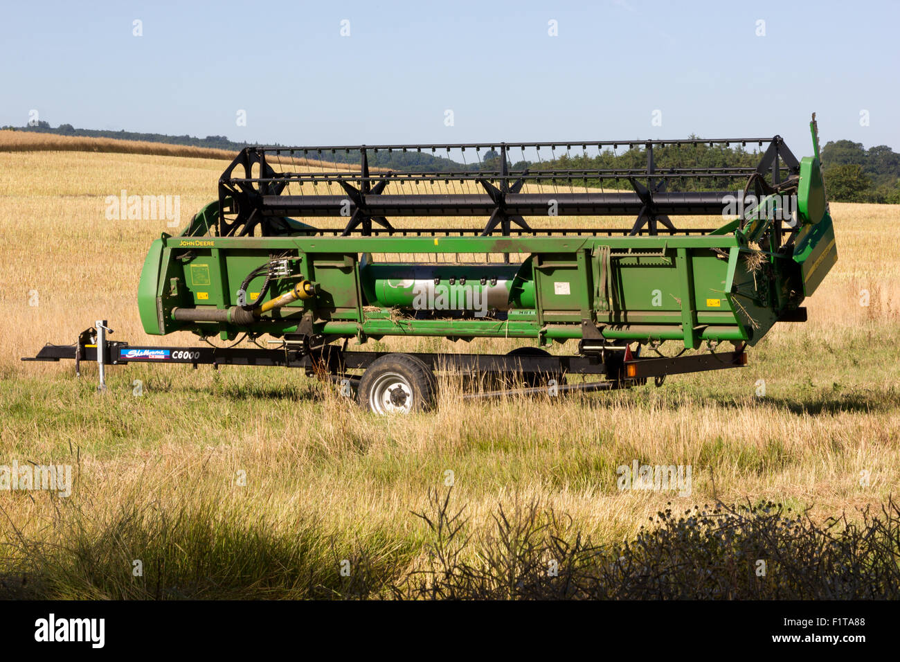 Harvesting tines from a combine harvester in a field at harvest time ...