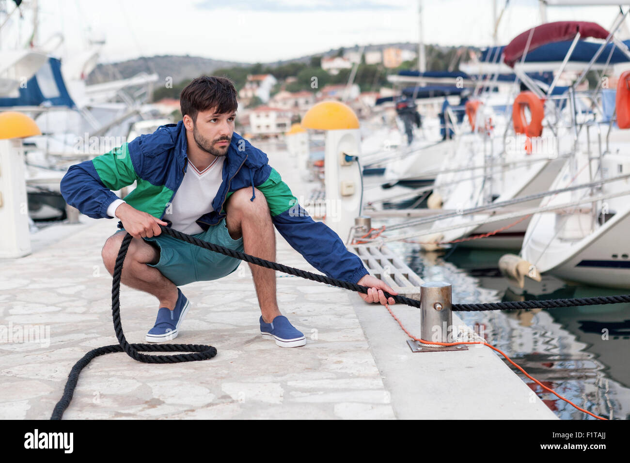Man fixing rope on pier, Adriatic Sea Stock Photo - Alamy