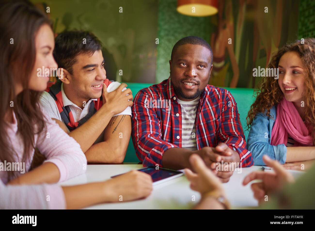 Friendly teens talking in cafe Stock Photo - Alamy