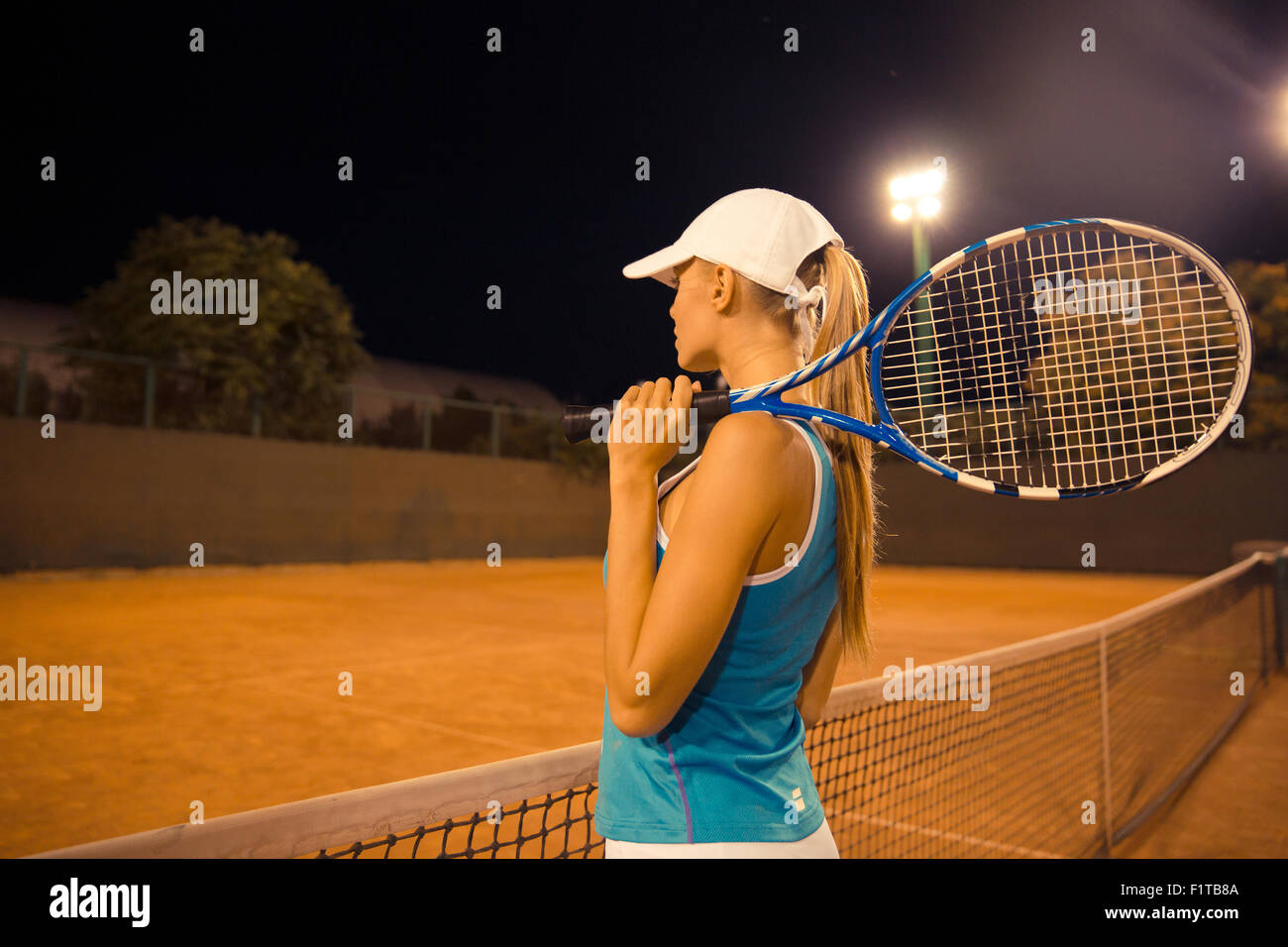 Side view portrait of sports woman holding tennis racket at court Stock ...
