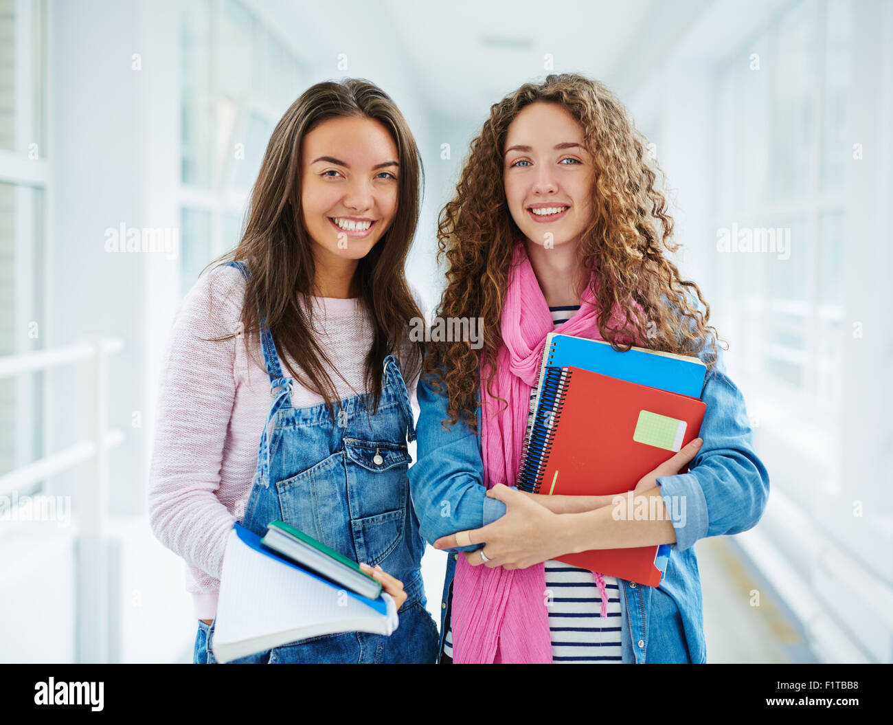 Happy teenage learners with books looking at camera Stock Photo - Alamy