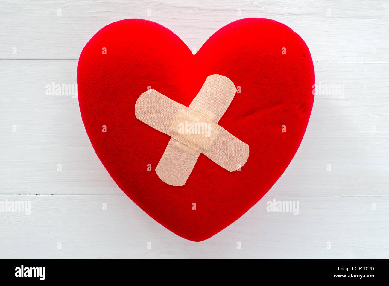 Injured heart with plaster on the white wooden surface Stock Photo - Alamy
