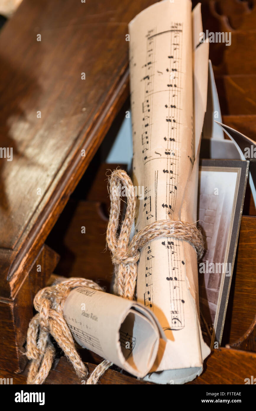 Rolled Music Sheet with aged photo over wooden drawer, composition ...