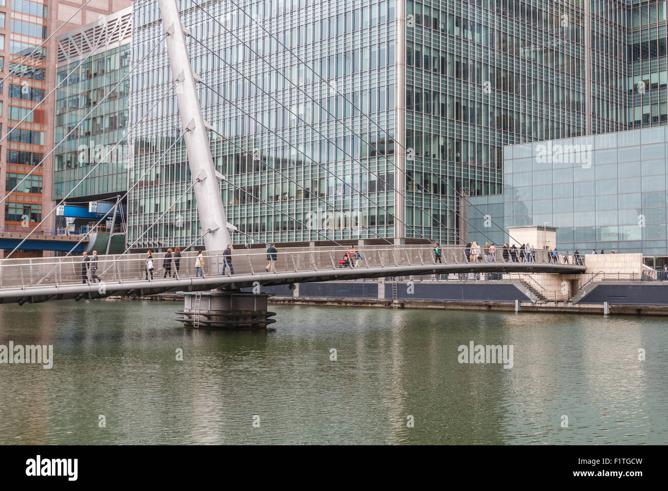 Office workers crossing Wilkinson bridge in London's Canary Wharf Stock ...