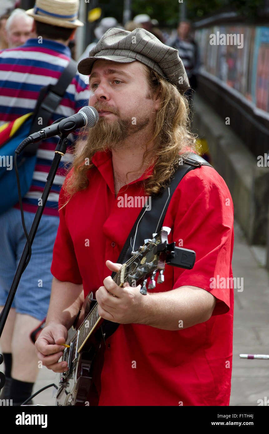 Singer/guitarist busking with his band during the Edinburgh Festival ...