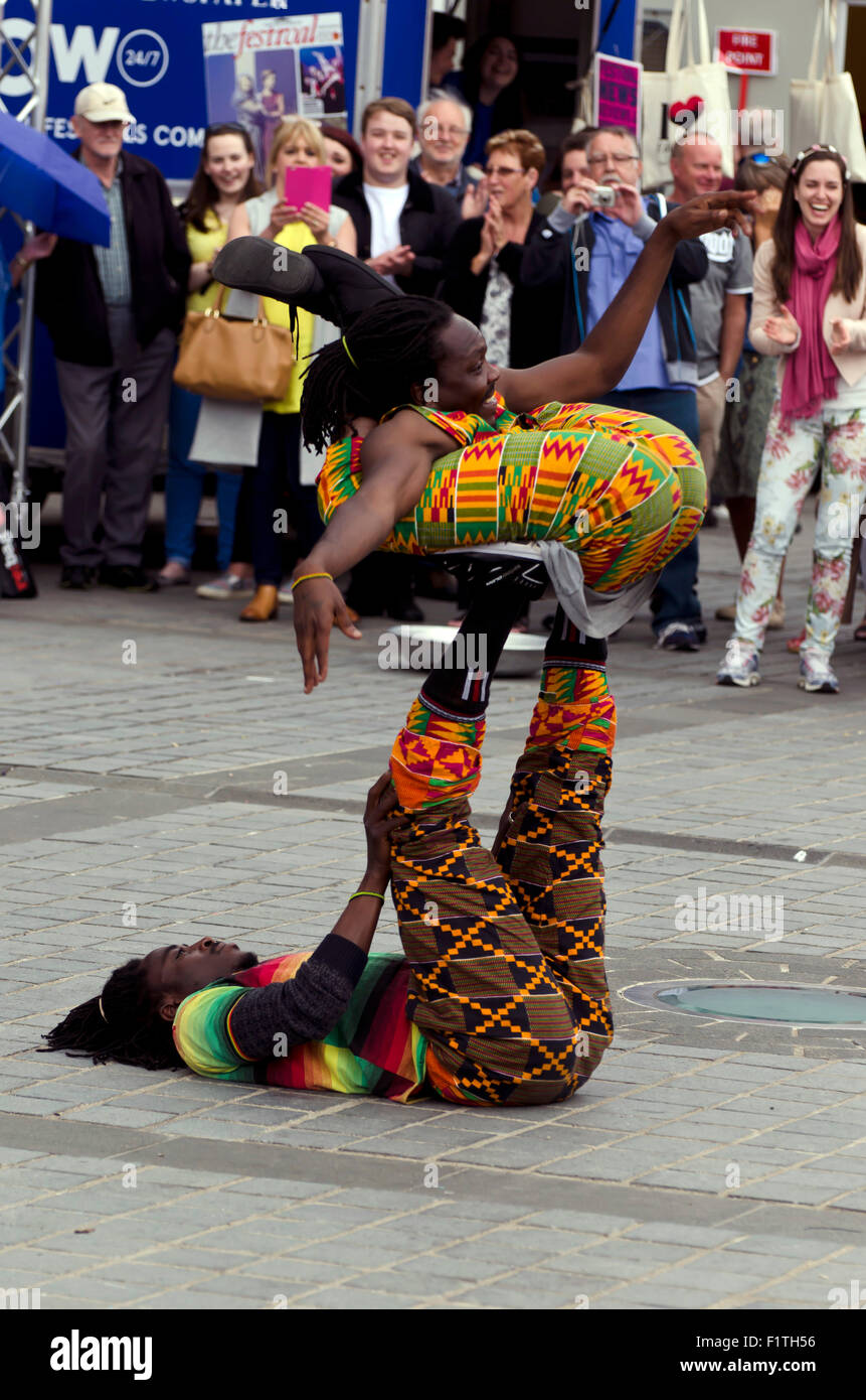 Members of an African acrobatic troupe performing a balancing act at ...