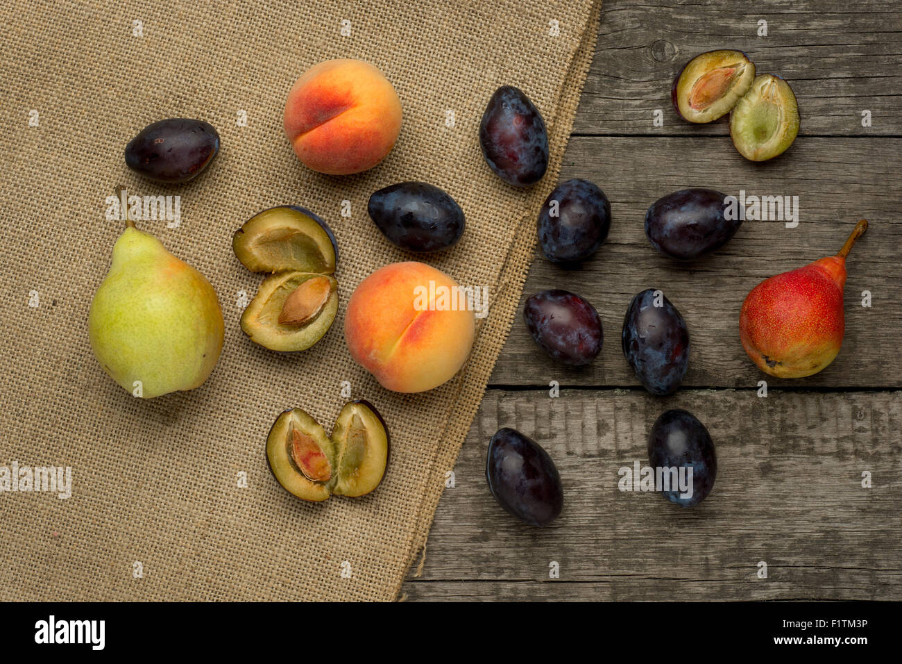 Ripe fruits of peach, plums and pear on rustic background Stock Photo ...