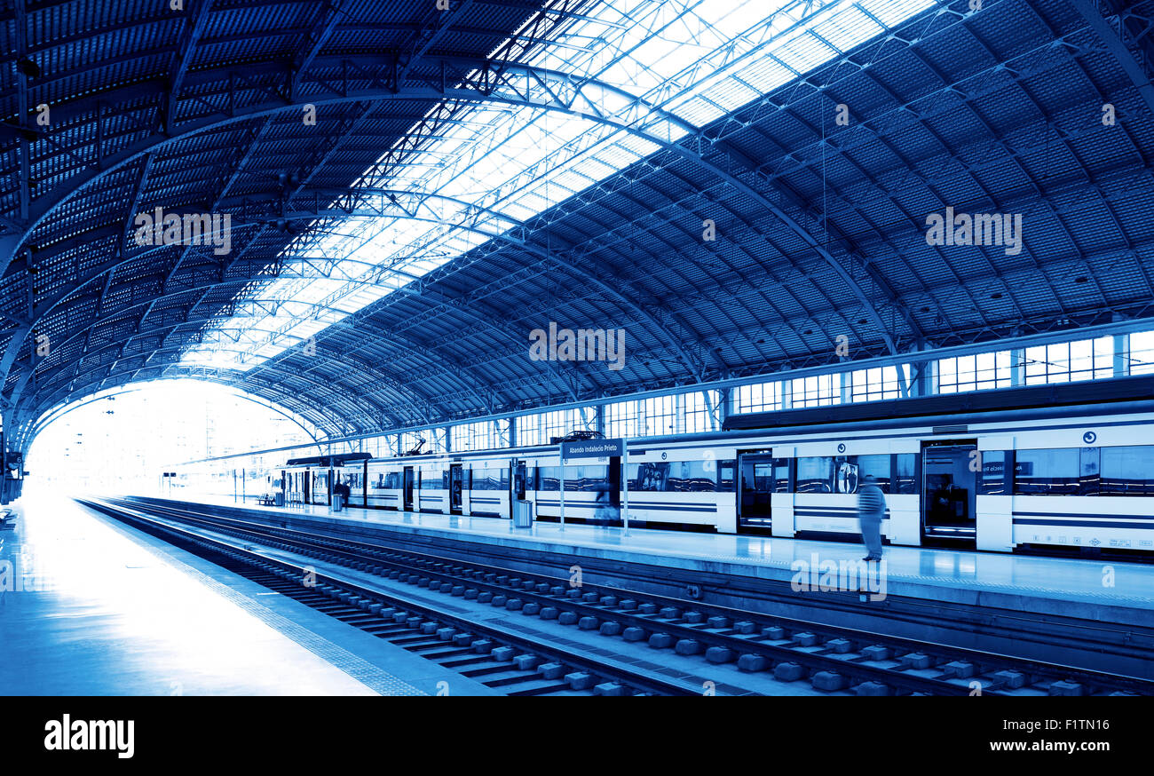 Railway station with train and people on blue tone Stock Photo - Alamy