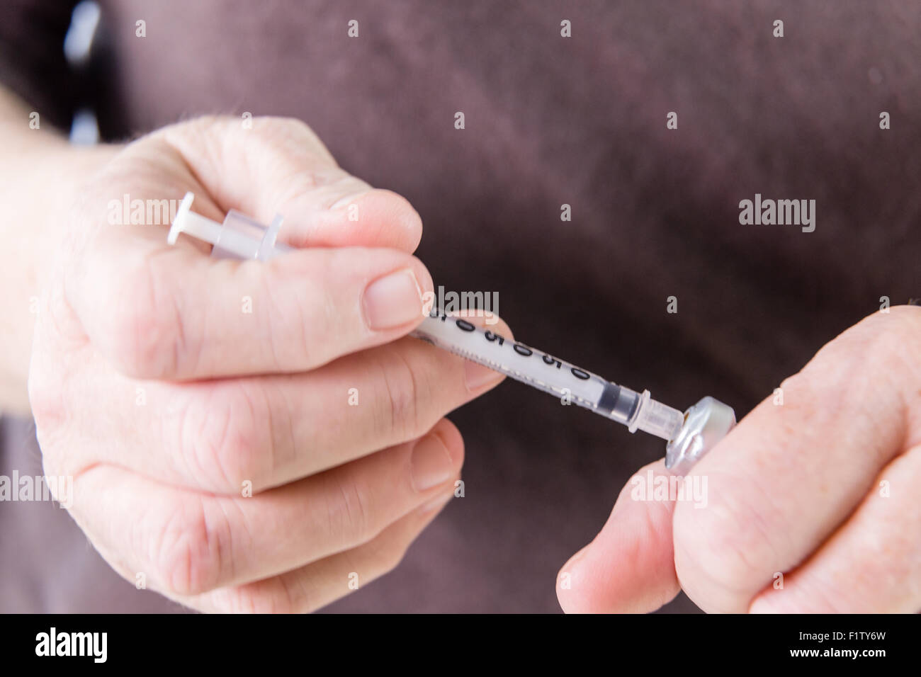 Drawing insulin from vial with syringe Stock Photo - Alamy
