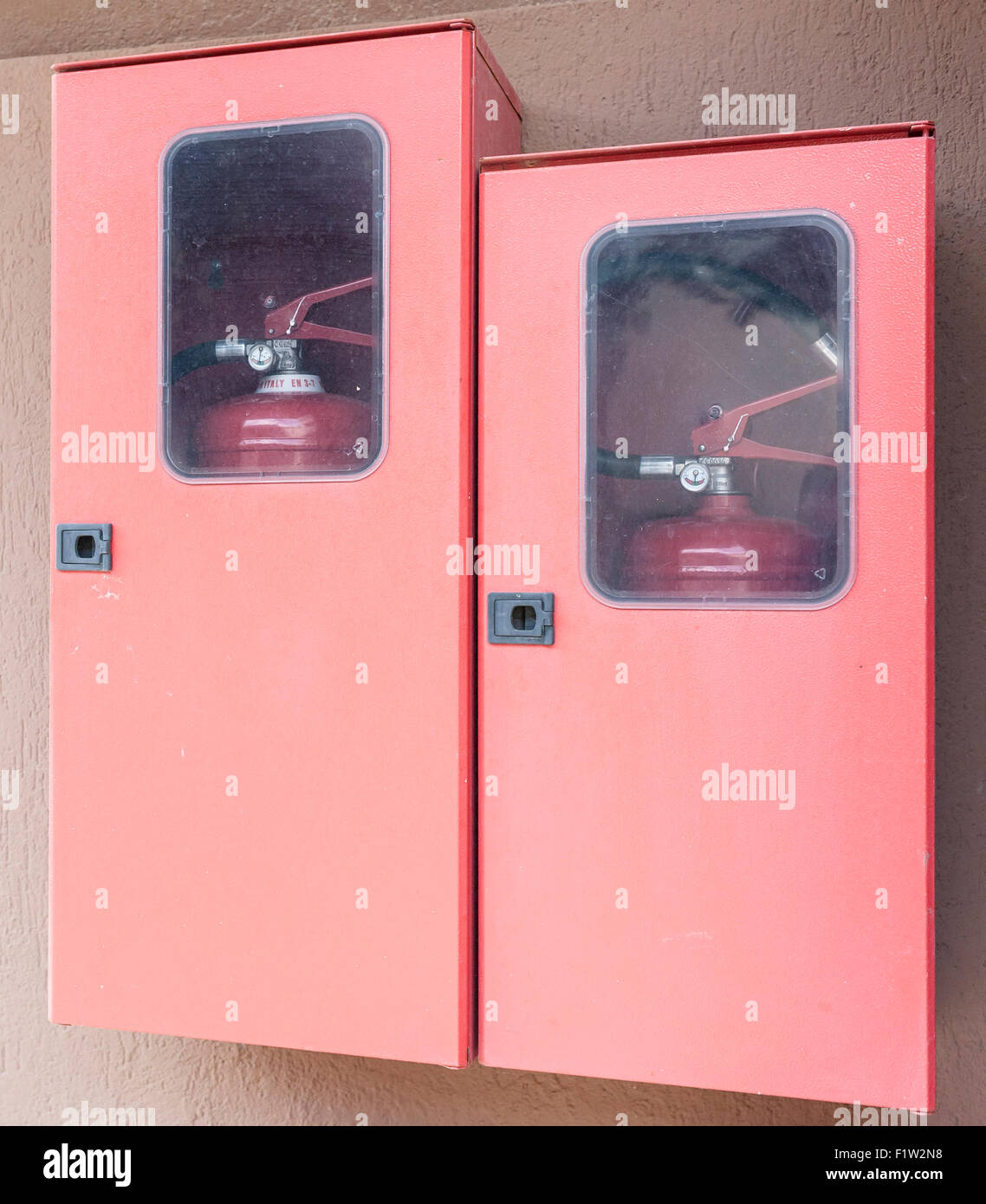 Two fire extinguishers in their lockers red Stock Photo - Alamy