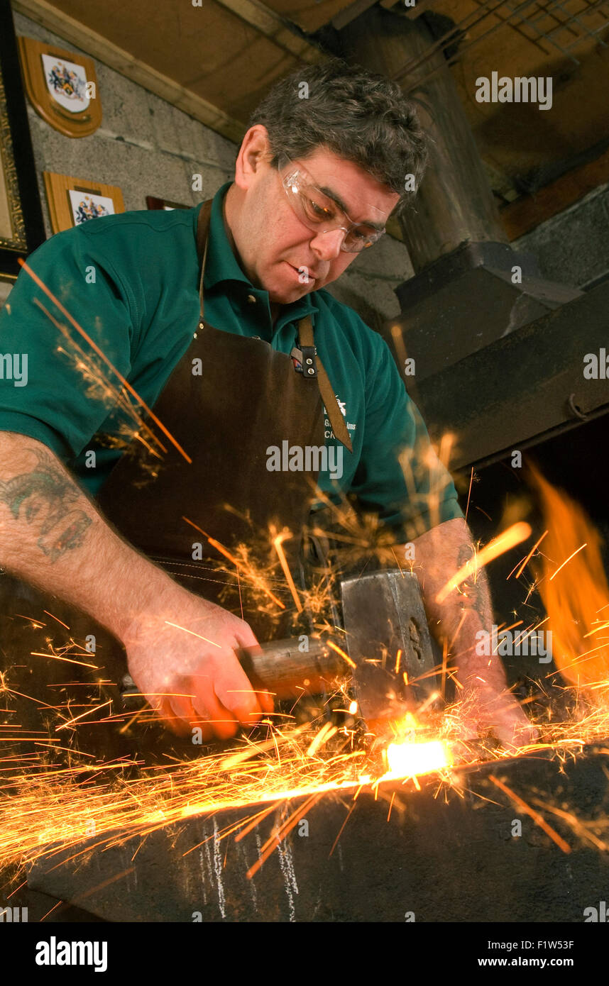 Blacksmith Simon Grant-Jones hammering hot metal with sparks flying,in ...