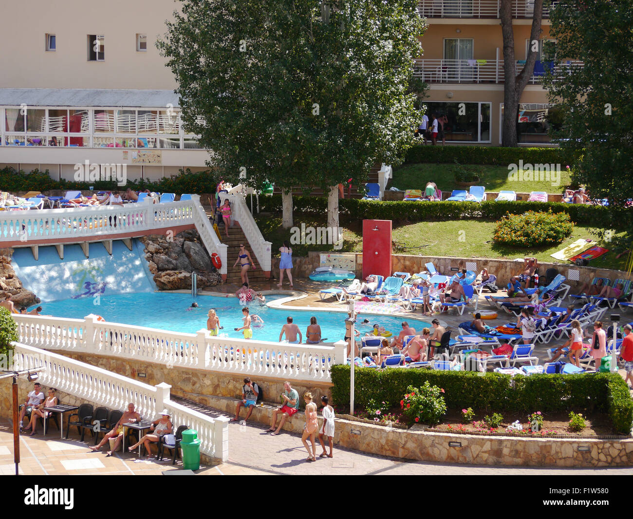 Tourists relaxing around a swimming pool at the Palma beach club resort ...