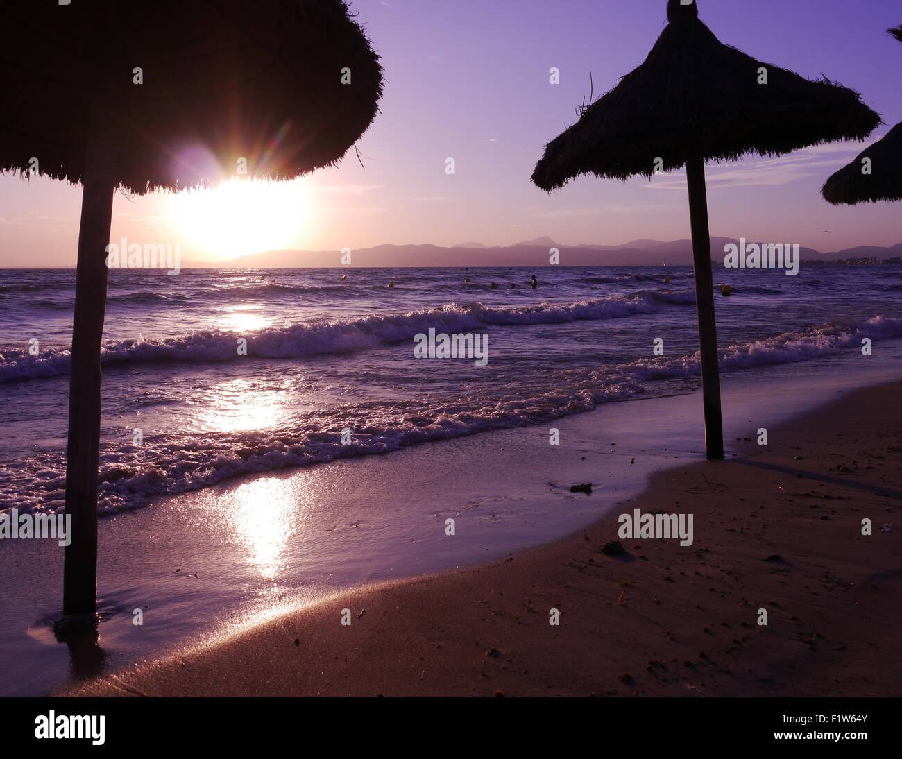 Palm sunshades on El Arenal Beach at sunset, Mallorca, Balearic Islands ...