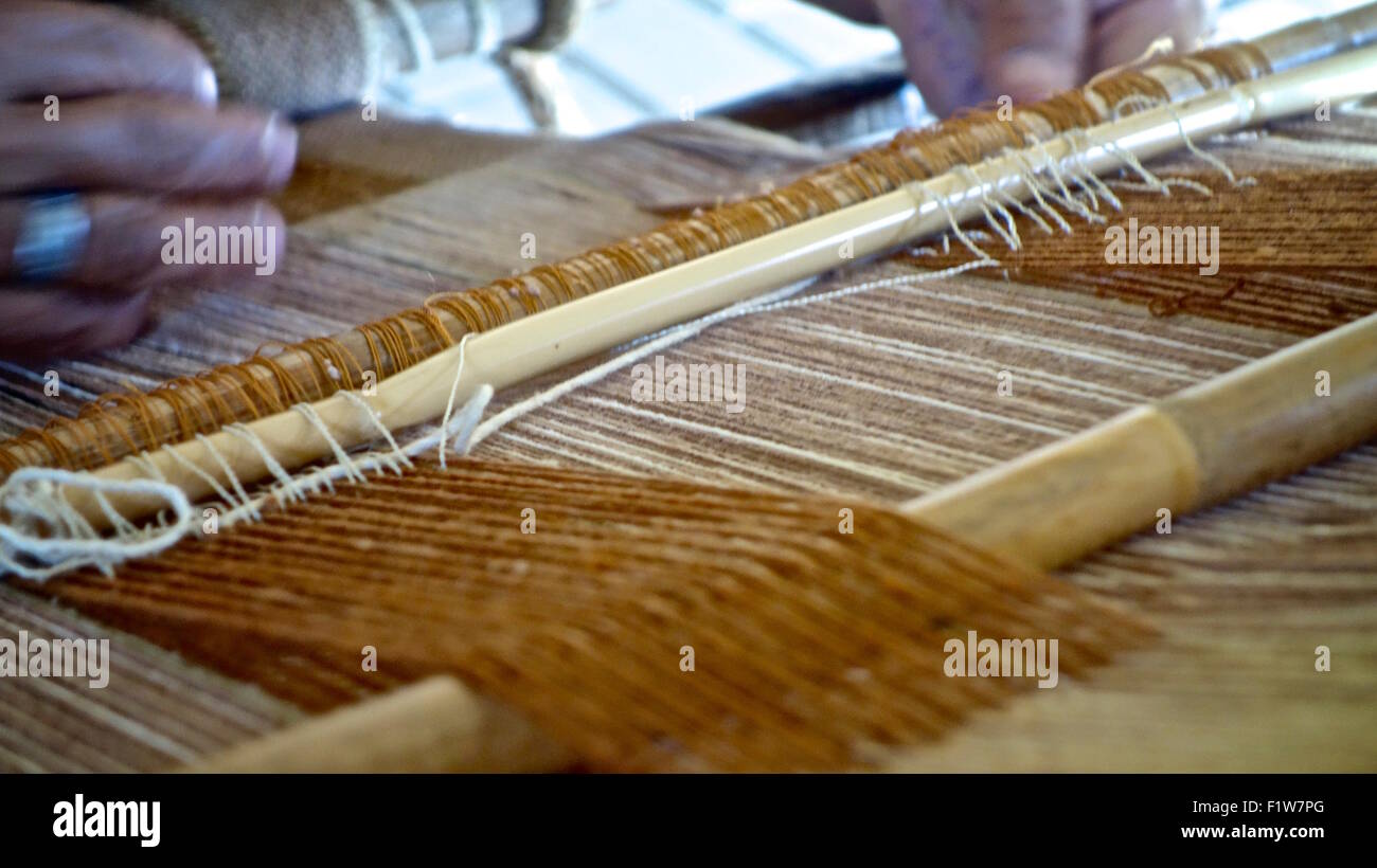 A Peruvian lady uses her hand loom to weave elaborate traditional ...