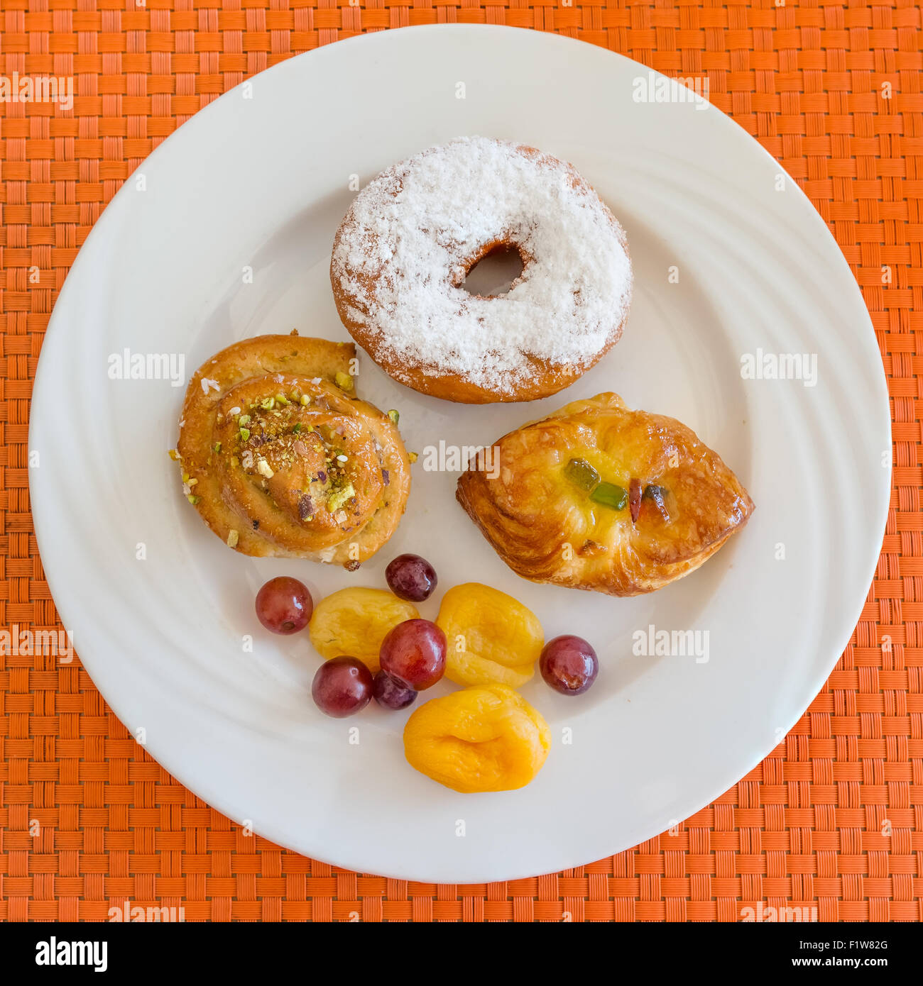 In the pictured three pastries served on a white plate with fruits as ...