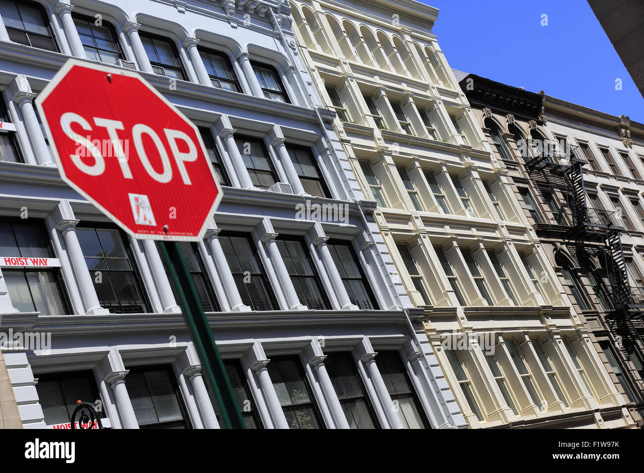 Stop sign with Cast-Iron buildings in Soho, Lower Manhattan, New York ...