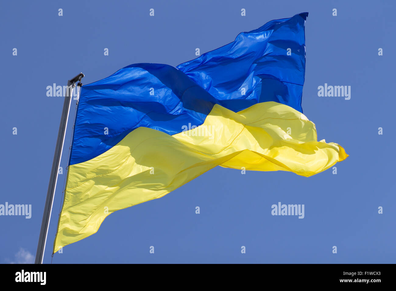 Ukrainian blue and yellow national flag waving in the air against sky ...