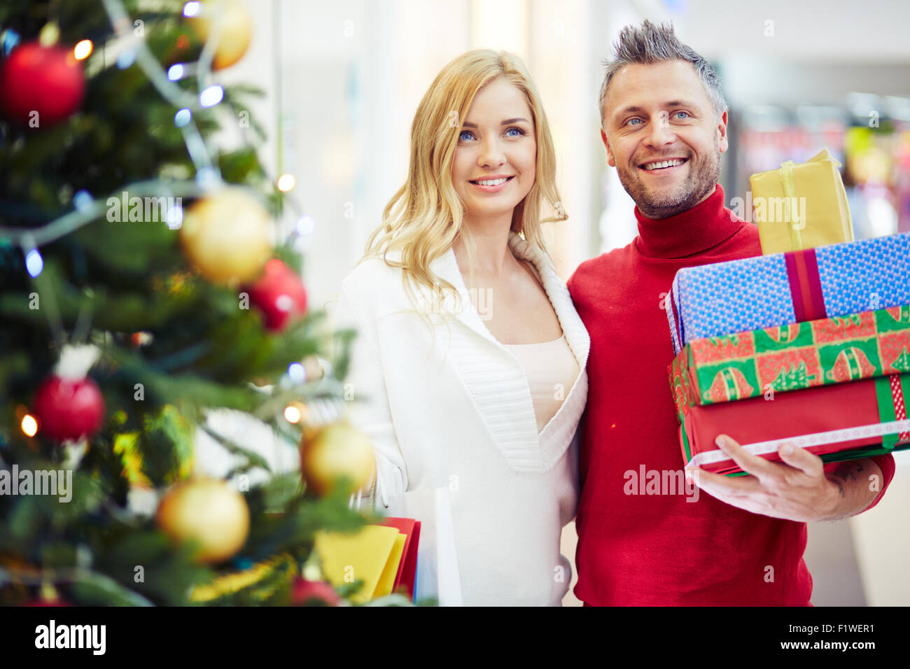 Cheerful shoppers with Christmas presents in the mall Stock Photo - Alamy