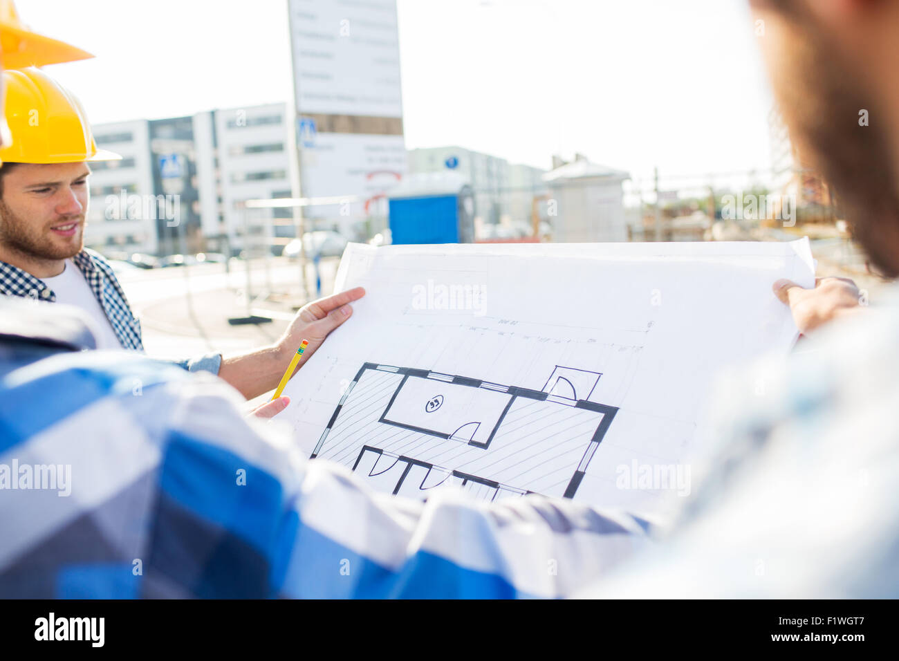 close up of builders with blueprint at building Stock Photo - Alamy