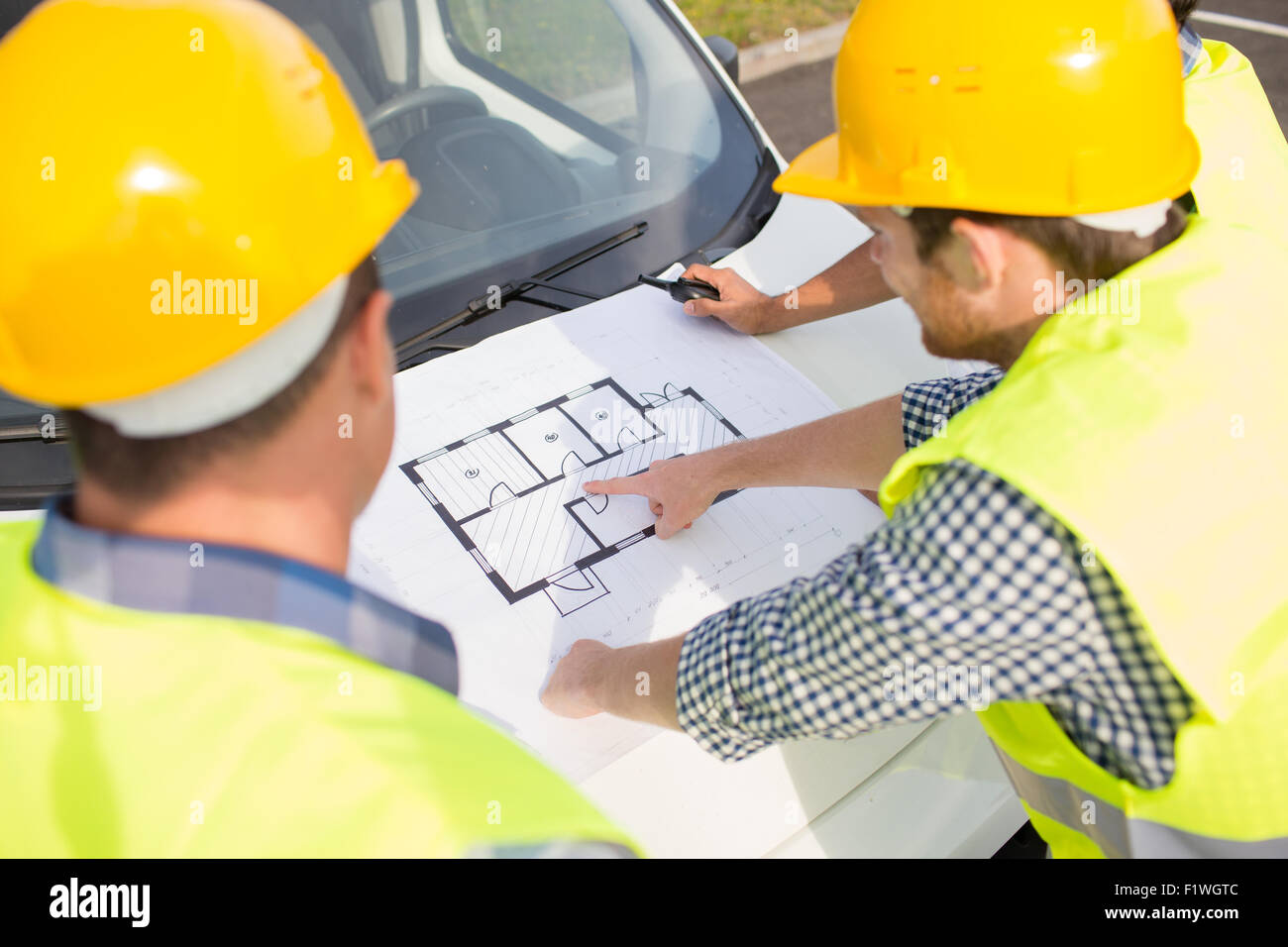 close up of builders with blueprint on car hood Stock Photo - Alamy