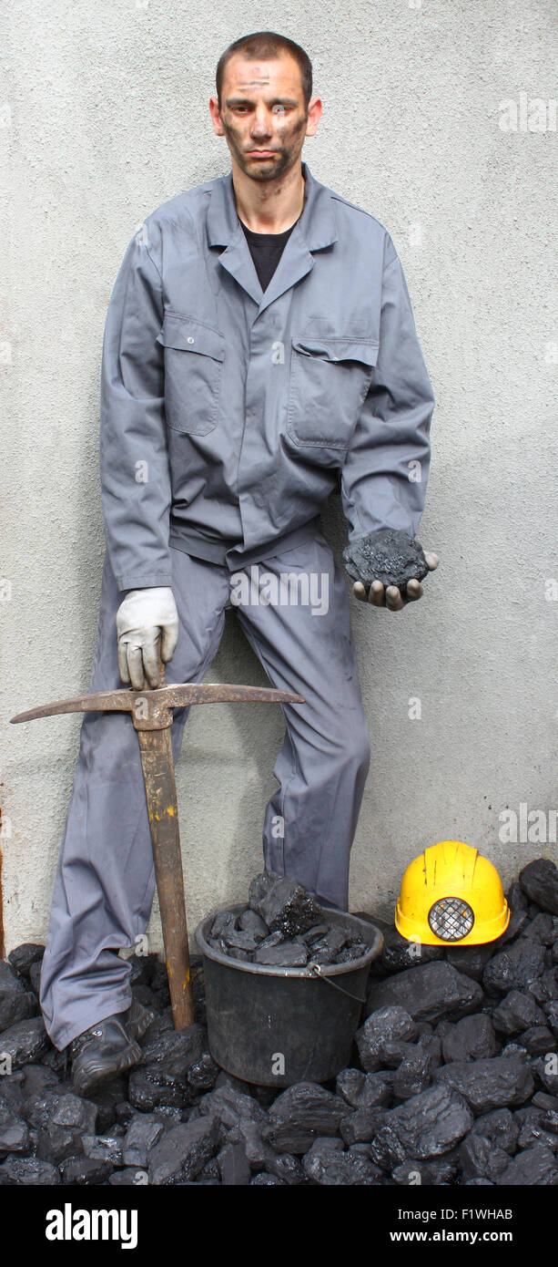 Holding a stone coal miner with a pickaxe mining Stock Photo - Alamy