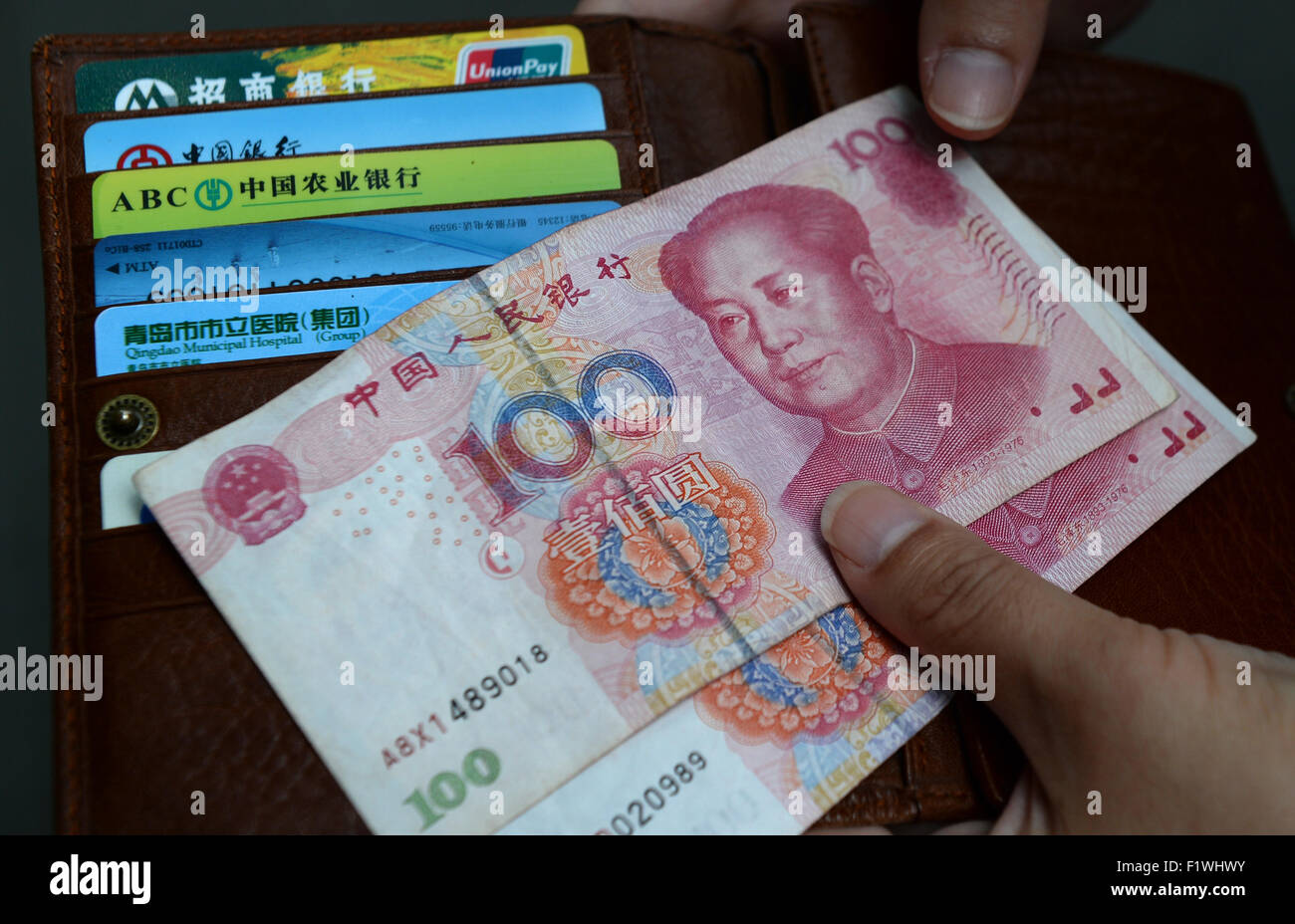 Shanghai, China. 30th Aug, 2015. A woman holds Chinese yuan banknotes ...